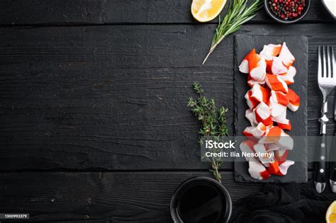 신선한 게 고기 스틱 수리미 푸른 수영 게 검은 나무 테이블 배경에 상단 보기 평면 누워 카피 스페이스와 텍스트 공간 가지 식물