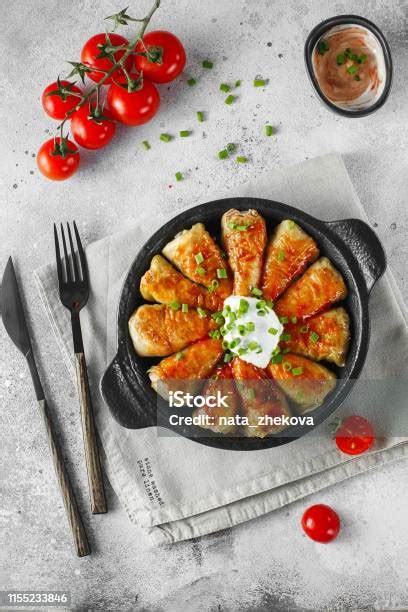 러시아 박제 양배추 롤은 토마토 녹색 양파와 회색 배경에 내 열 블랙 요리의 사 워 크림과 함께 제공 됩니다 음식 사진 소고기에