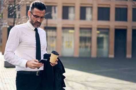 성공적인 성숙한 사업가 4 G 인터넷 당신의 광고에 대 한 모의 커피와 함께 산책을 사용 하 여 Smartphone에 소셜 네트워크에 현대 기술에 대 한 정보를 검색 하는