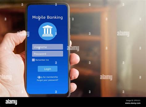 Male Hand Holding Mobile Phone With Online Banking App Interface On The Screen Login Page With