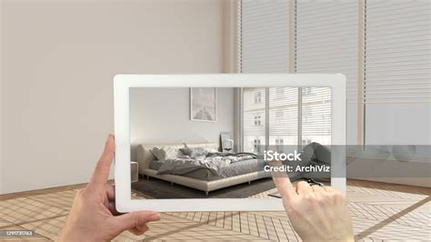 증강 현실 개념 쪽모이 세공 마루 바닥 장식이있는 현대적인 침실이있는 빈 인테리어에서 가구 및 디자인 제품을 시뮬레이션하는 데 사용되는 Ar 응용 프로그램과 핸드 홀딩