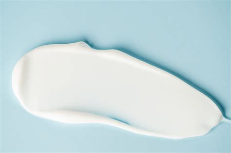 파스텔 블루 배경에 화이트 코스메틱 페이스 크림 또는 바디 로션 모이스처라이저 스트로크 크리미한 질감의 위생 스킨케어 제품 컬러