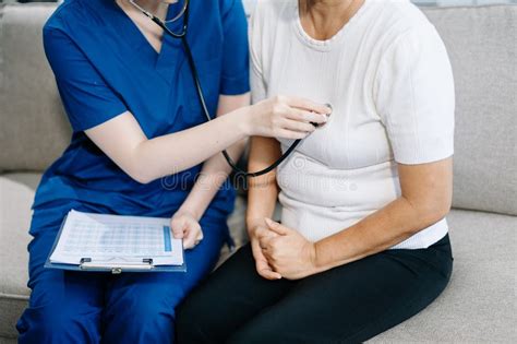Asian Caregiver Doctor Examine Older Patient Woman Therapist Nurse At