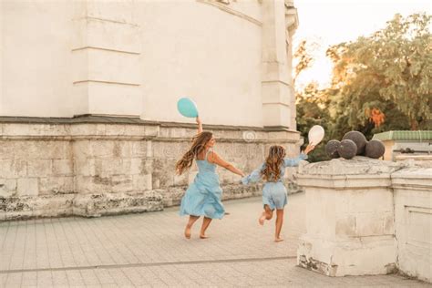 Hija Madre Corriendo De La Mano En Vestidos Azules Con El Pelo Largo