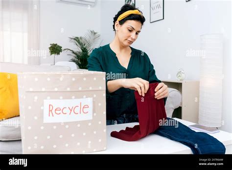 A Thoughtful Woman Is Actively Engaged In Sorting Out Clothes Choosing