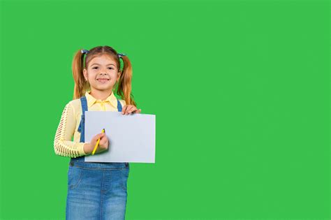 광고를위한 빈 측면 공간이있는 녹색 배경에 흰색 시트를 들고 미소를 가진 귀여운 어린 소녀 공란에 대한 스톡 사진 및 기타 이미지 공란 귀여운 녹색 Istock