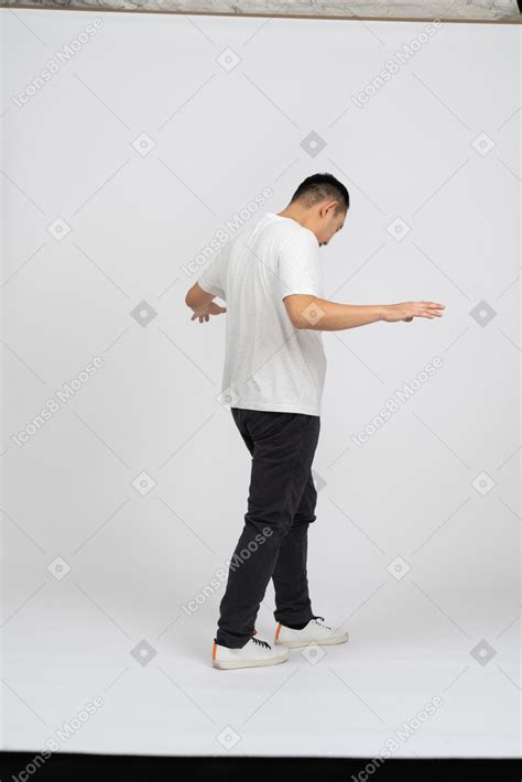 팔을 쭉 뻗고 걷는 캐주얼 옷을 입은 남자의 옆모습 사진