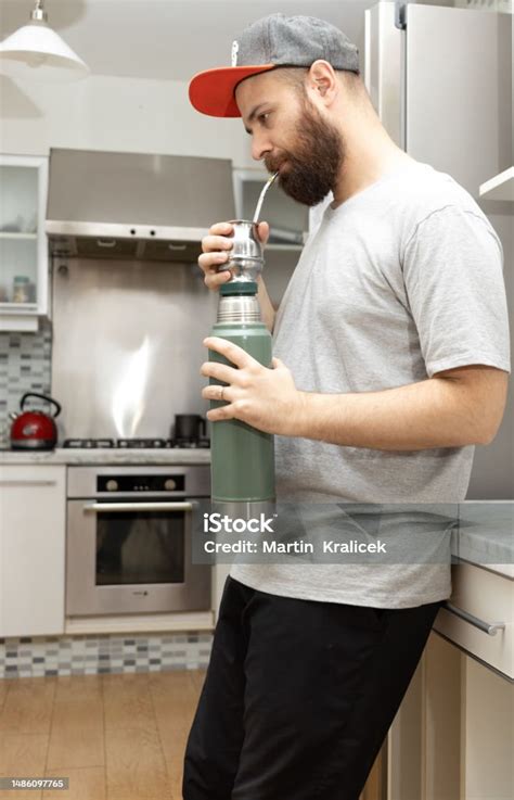 부엌에서 전통적인 아르헨티나 우루과이 음료를 마시는 남자 모자를 쓴 수염 난 남자 손에 뜨거운 물통 30 34세에 대한 스톡 사진 및 기타 이미지 Istock