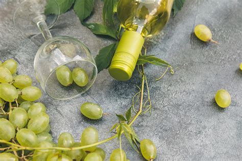 빈티지 그레이 스톤 테이블 배경에 병 화이트 와인 녹색 포도 와인 잔과 잘 익은 포도의 최고 보기 와인 숍 와인 바 와이너리 또는 와인 시음 개념 0명에 대한 스톡 사진 및