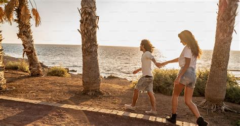 아름다운 커플은 바다 해안을 걷고 손을 잡고 함께 일몰 시간을 즐긴다 실제 사람들의 감정과 사랑 개념 사진 Unsplash의 바깥 이미지