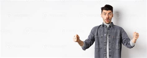 Confused Man Holding Big Size Object And Looking Shocked Shaping Large