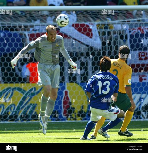 Australias Goal Keeper Mark Schwarzer Heads The Ball Away From Atsushi