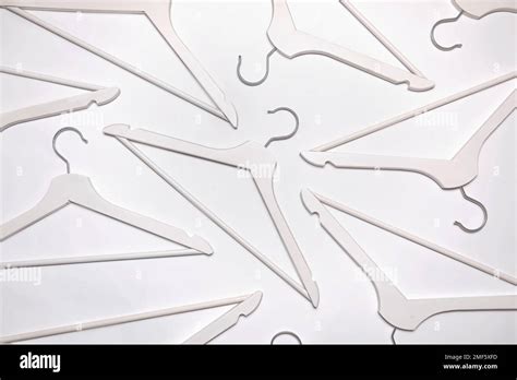 Pattern Of Empty White Hangers Flat Lay On White Background Abstract