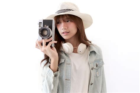 청바지 재킷 여름 모자를 쓴 아시아 젊은 여성 여행자가 인상적인 사진을 찍기 위해 필름 카메라를 들고 있습니다 배경에 그녀의 고전적인 오래 된 필름 카메라를 가진 여성 십대