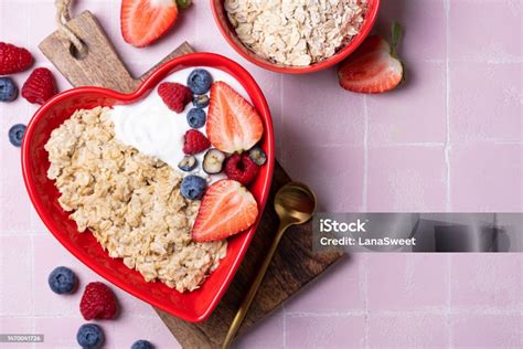 심장 모양 상위 뷰에 빨간 그릇에 베리와 요구르트를 곁들인 오트밀 죽 귀리 플레이크 건강한 아침 식사 깨끗한 식생활 다이어트 건강식품 하트 모양에 대한 스톡 사진 및 기타