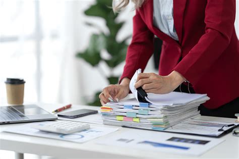 종이 파일 더미에서 일하는 여성 사업가 데이터 그래프 문서를 찾아 지워진 작업을 검토하고 여전히 백로그 사무실 책상에서 실패한