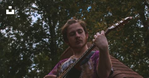 보라색과 흰색 긴 소매 셔츠를 입은 여자가 갈색 어쿠스틱 기타를 들고 있다 사진 Unsplash의 무료 기타 이미지