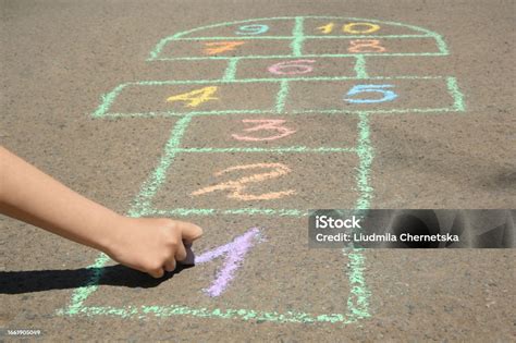 야외에서 아스팔트에 화려한 분필로 돌차기 놀이를 그리는 아이 클로즈업 돌차기놀이에 대한 스톡 사진 및 기타 이미지 돌차기놀이