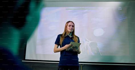 새로운 네트워크 비디오 게임의 젊고 자신감 있는 여성 개발자로 프레젠테이션 중 대형 화면 옆에 디지털 태블릿이 서 있다 사진