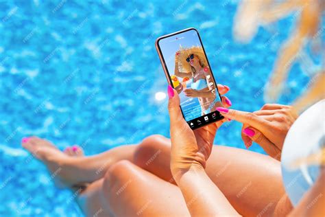 Premium Photo Woman Using Video Sharing Social Media App On Mobile Phone While Sitting By The Pool