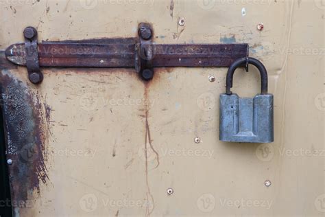a rusty lock and latch attached to a vintage door highlighting