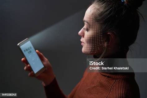 여성은 생체 인식을 위해 휴대 전화의 얼굴 인식 시스템을 사용하여 얼굴을 스캔합니다 미래 하이테크 기술 및 얼굴 Id 사람