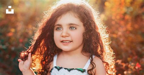 낮 동안 푸른 잔디밭에 서 있는 흰색과 청록색 민소매 드레스를 입은 소녀 사진 Unsplash의 무료 꼬마 이미지