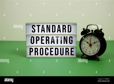 Standard Operating Procedure Text On Led Lightbox With Alarm Clock On