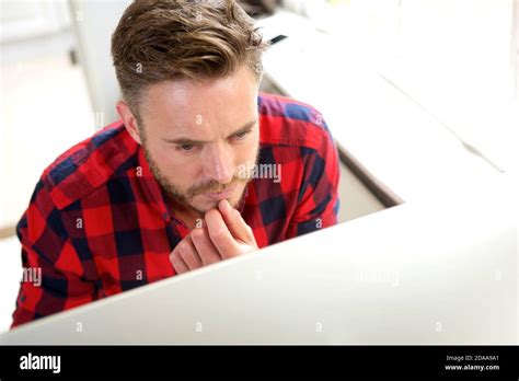 Portrait Of Attractive Business Man Thinking Behind Computer Screen Stock Photo Alamy