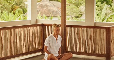 명상 휴식과 정신 균형을 위한 명상 건강한 라이프 스타일을위한 홈 요가 연습 연꽃의 낮은 좌석에 앉아 있는 성숙한 여자는 테라스에서 포즈를 취한다 사진