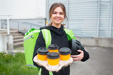 음식 배달 개념 커피 또는 차 배달 여성은 녹색 냉장고 배낭을 가지고있다 그녀는 더 빨리 제공하고 고객에게 도달하고 싶어합니다 그녀는 우리에게 음식을 가져다 주었고 그녀가