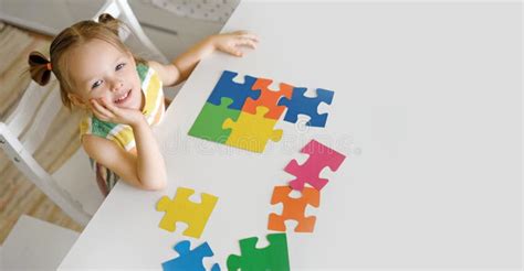 A Cute Little Innocent Girl Is Sitting At A Table With Large Colorful