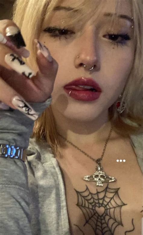 A Woman With Tattoos And Piercings On Her Chest