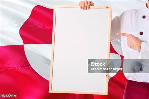 그린란드 국기 배경에 빈 화이트 보드 메뉴를 들고 요리사 텍스트에 대 한 균일 한 포인팅 공간을 착용 요리 고급 요리에 대한 스톡 사진 및 기타 이미지 Istock