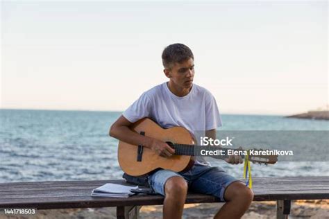 젊은 세련된 남자가 바다 제방에서 기타를 연주 음악과 휴식의 개념 가수에 대한 스톡 사진 및 기타 이미지 가수 거리 기타