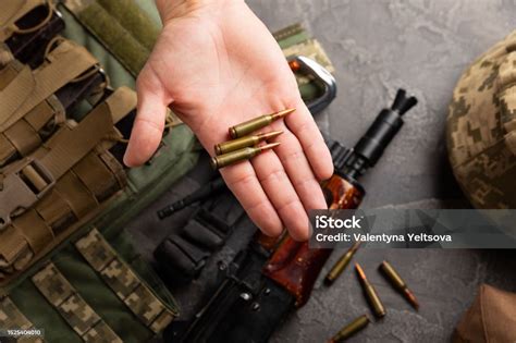 질감 대리석에 콜라시니코프 돌격 소총이 있는 총알과 탄약 탄창 텍스트에 대한 장소가있는 구성입니다 나무 배경에 소총과 카빈총 카트리지 군사 개념입니다 복사 공간 Ak 74