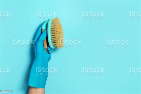 파란색 배경에 브러시를 들고 장갑에 손을 공간을 복사합니다 청소 집 청소 화장실 개념 청소 서비스 개념 가정용 화학 적 세척 제품 브러시 및 용품 가사 집안일에 대한 스톡