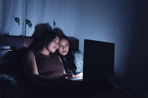 두 명의 히스패닉 젊은 여성이 침대에 누워 노트북으로 어둠 속에서 영화를 보는 세로 샷 2명에 대한 스톡 사진 및 기타 이미지 2명 갈색 머리 감정 Istock