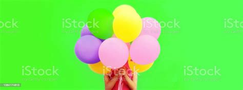 그녀의 머리를 덮고 녹색 배경에 화려한 풍선의 손 무리에 들고 알 수없는 여자의 축제 이미지 25 29세에 대한 스톡 사진 및 기타 이미지 Istock
