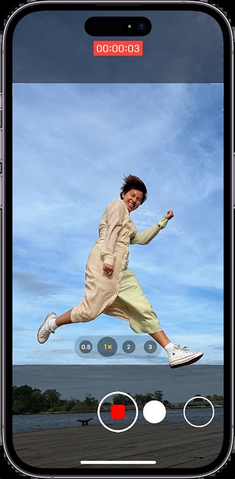 处于“照片”模式的“相机”屏幕。主体位于相机取景框内，填满屏幕中央。屏幕底部的快门按钮移到右侧，演示了开始录制快录视频的操作。视频计时器位于