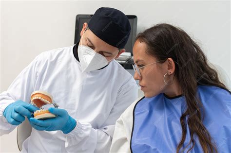 Hombre Dentista Sosteniendo Un Modelo Dental Dando Una Explicación A Un