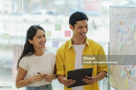 젊은 아시아 사업가와 사업가가 회의에서 투자 프로젝트 작업 및 계획 전략에 대해 논의합니다 사무실에서 태블릿과 함께 이야기하는 비즈니스 사람들 2명에 대한 스톡 사진 및