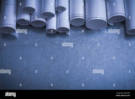 Rolled White Blueprints On Scratched Metallic Surface Copy Space Image Construction Concept
