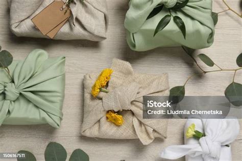 후로시키 기술 직물 꽃 유칼립투스 잎으로 포장 된 많은 선물이 나무 테이블에 평평하게 놓여 있습니다 후로시키에 대한 스톡 사진 및 기타 이미지 Istock