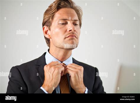Serious Businessman Adjusting Tie Stock Photo Alamy