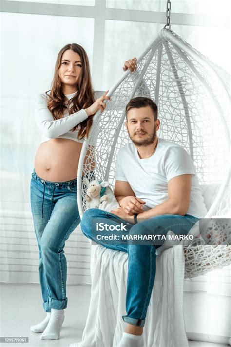 그녀의 남편과 임신 한 소녀가 밝은 침실에 서있다 젊은 매력적인 임신 소녀의 아름다운 배 가족 결혼 출산 개념 25 29세에 대한 스톡 사진 및 기타 이미지 Istock