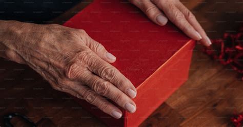 나무 테이블 위에 빨간 상자를 들고 있는 사람 사진 Unsplash의 선물 포장 이미지