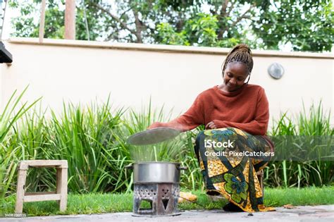 전통적인 야외 난로에서 요리하는 끓는 냄비에 뚜껑을 들어 올리는 젊은 여성 불에 대한 스톡 사진 및 기타 이미지 불 요리하기 음식 준비 20 24세 Istock