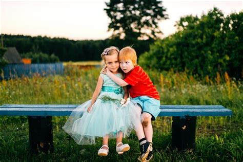 پسر کوچک بامزه دختر زیبا و خجالتی را در لباس بغل می کند 1567059