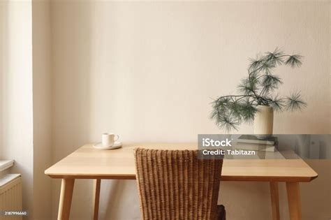 크리스마스 아침 식사 정물 최소한의 겨울 구성 커피 차 접시의 흰색 컵 꽃병에 꽂힌 소나무 가지 등나무 의자가 있는 나무 탁자에 오래 된 책 우아한 스칸디나비아 거실 0명에